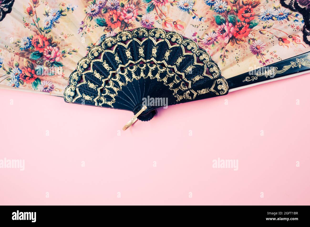 Top view of a beautiful floral hand fan on the pink surface Stock Photo ...