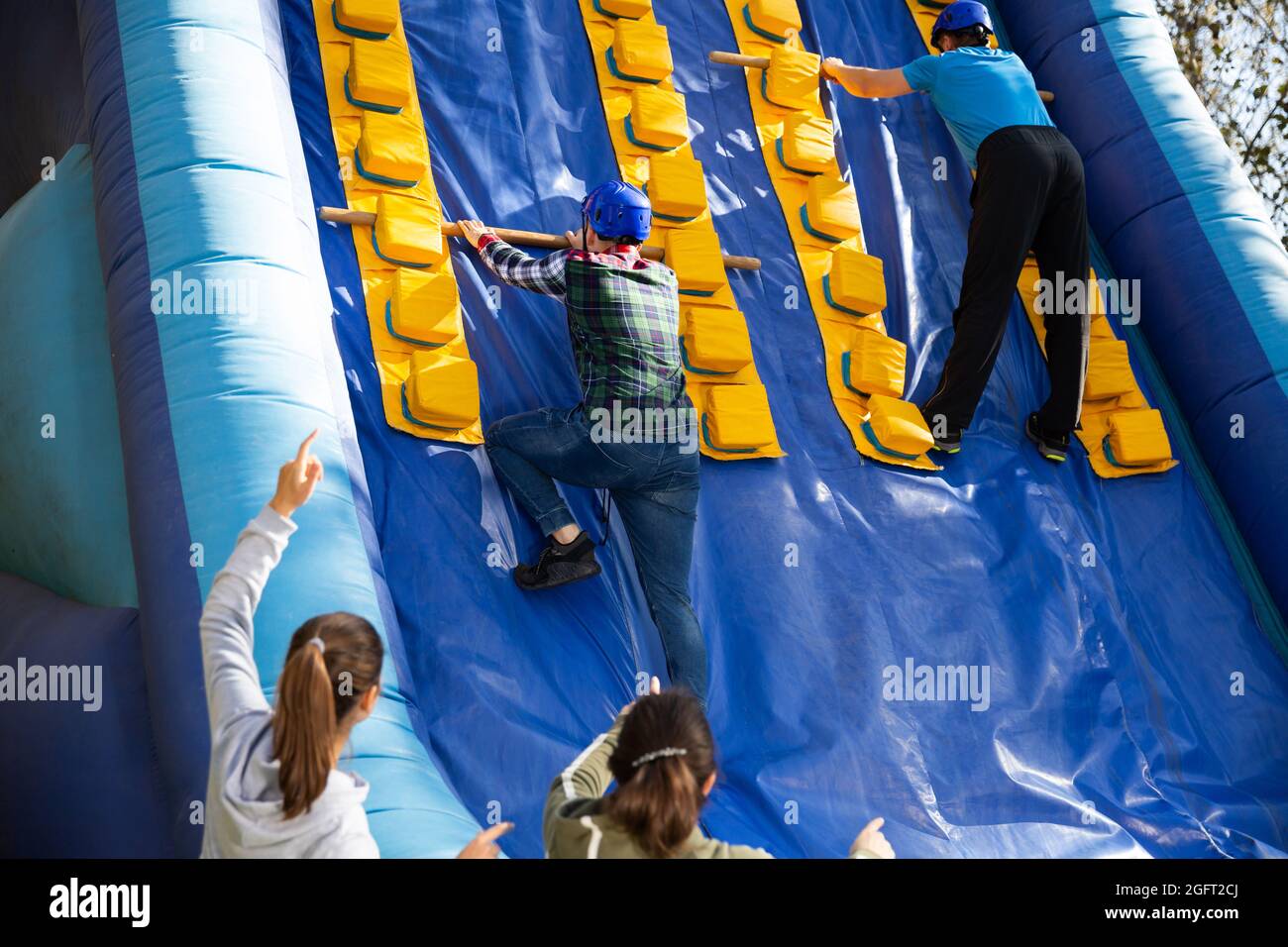 Friends having fun passing obstacle course Stock Photo - Alamy