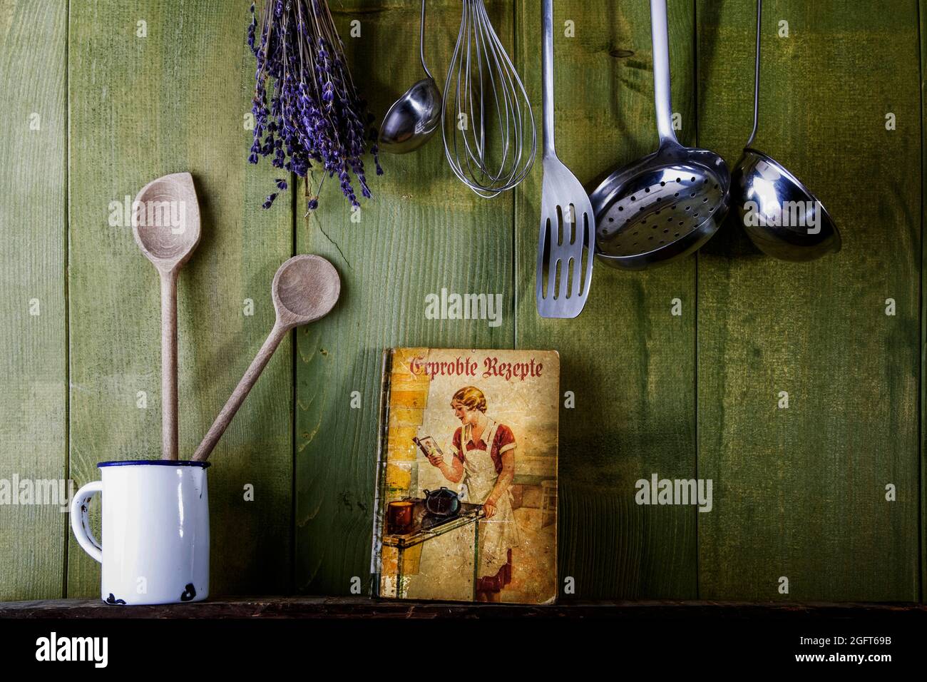 old cookbook with kitchen utensils in front of green wooden wall Stock ...