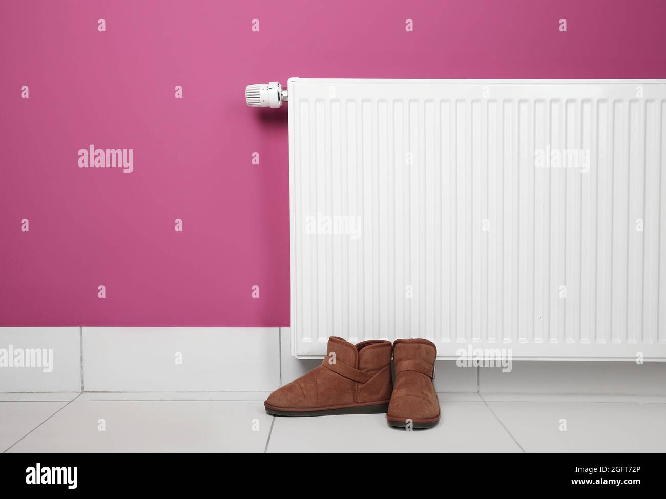 Shoes standing near heating radiator in the room Stock Photo - Alamy