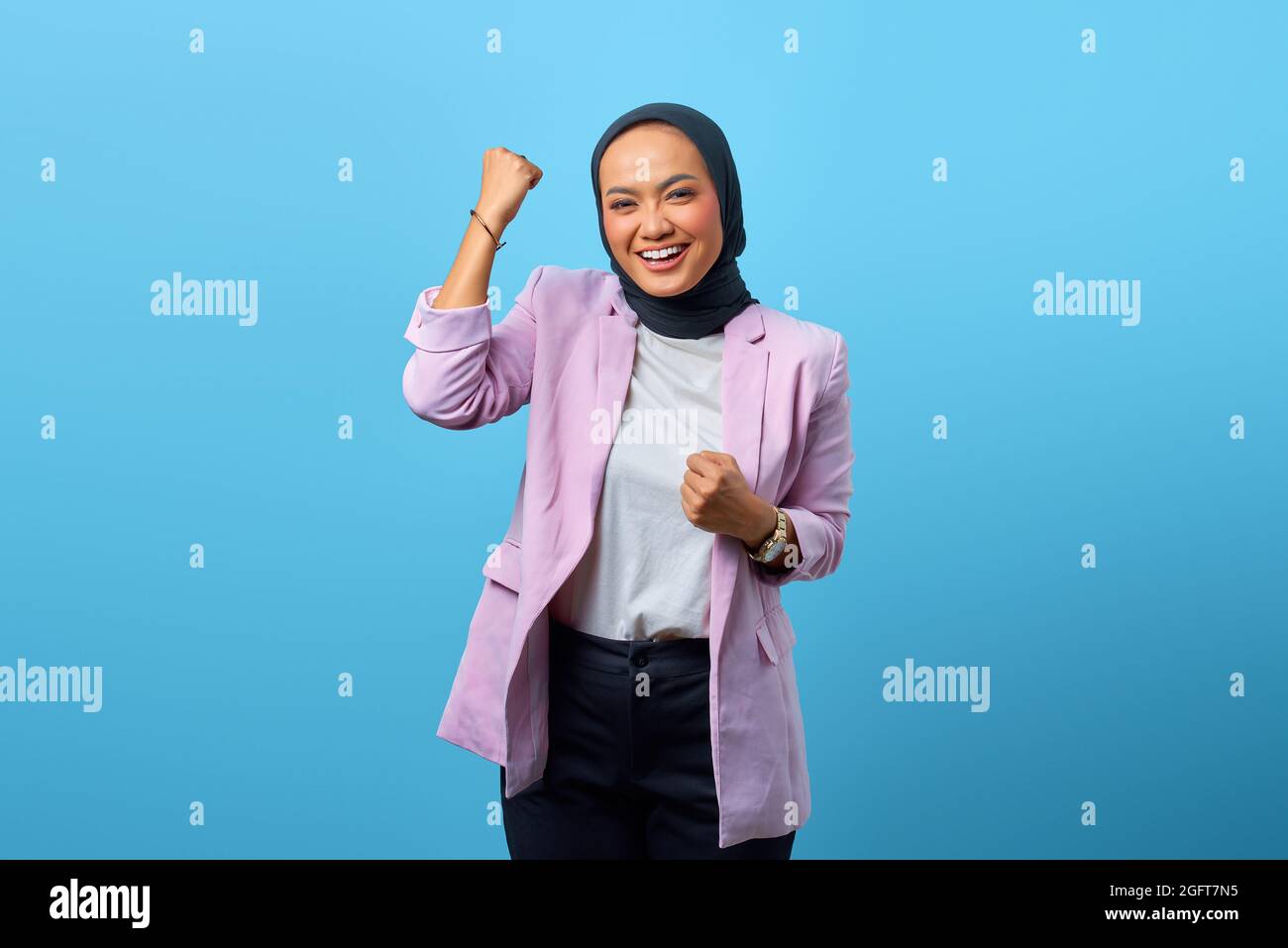 Excited Asian woman celebrating luck and making victory gesture over ...