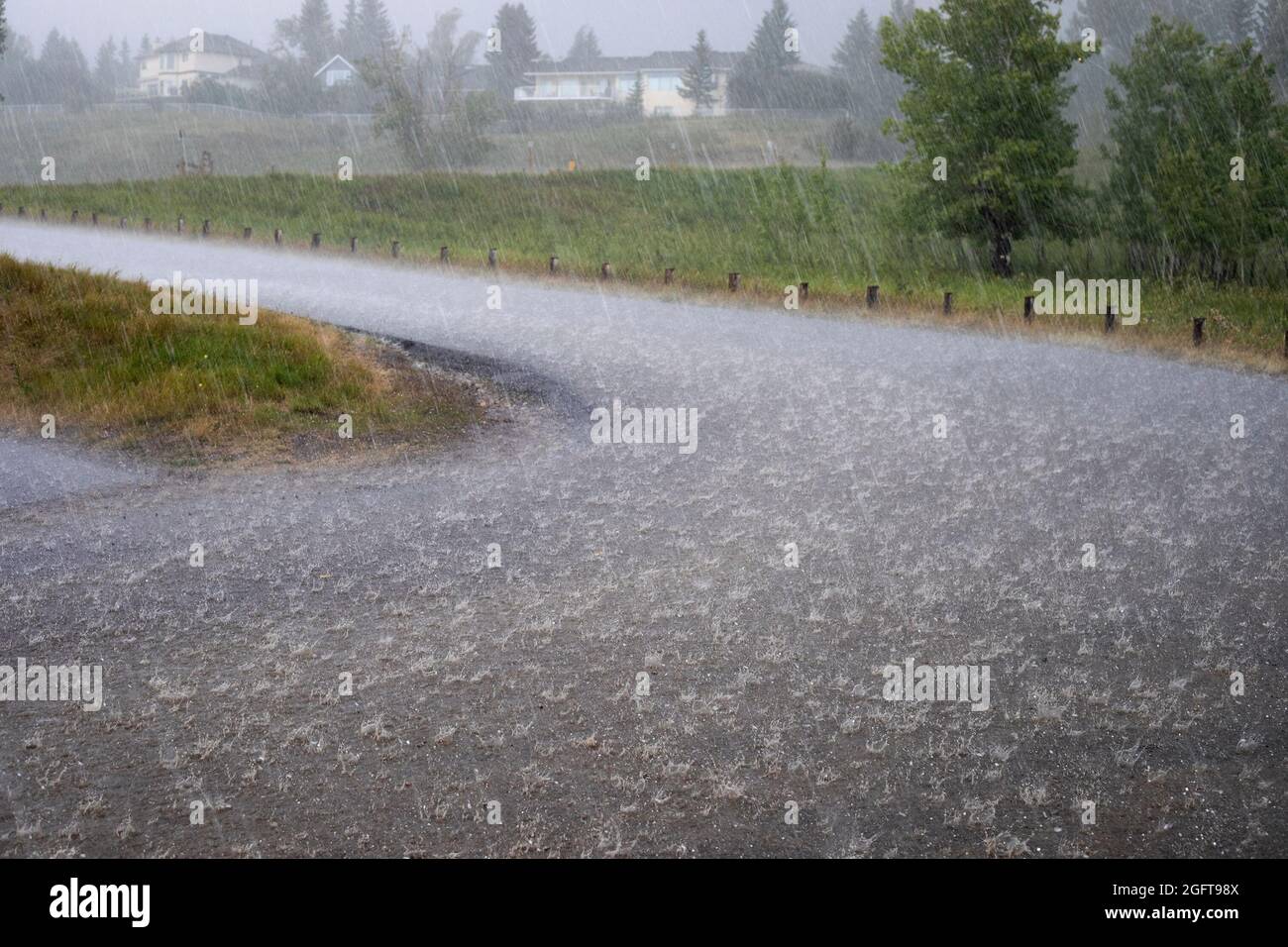 Hail falling during an intense rain storm in a suburban neighbourhood ...