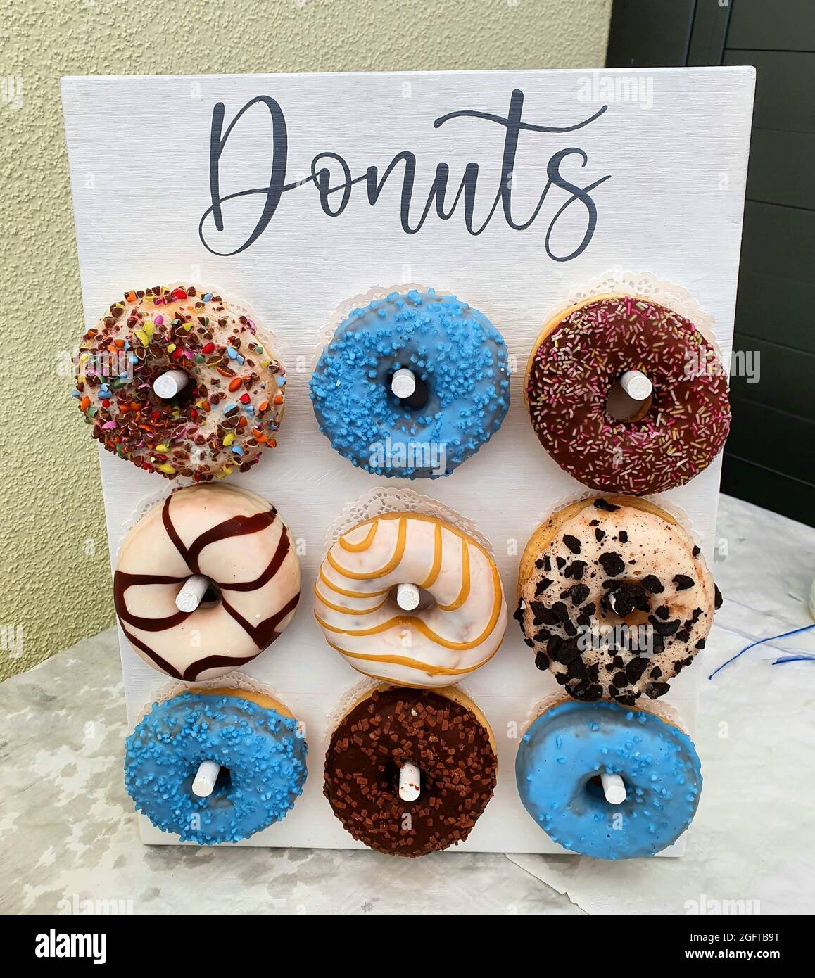 Colorful and sweet donuts on a wooden display rack Stock Photo - Alamy