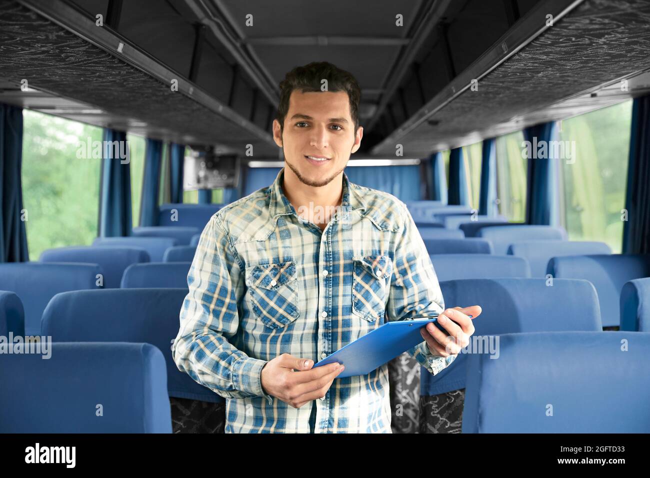 Conductor inside bus with clipboard Stock Photo - Alamy