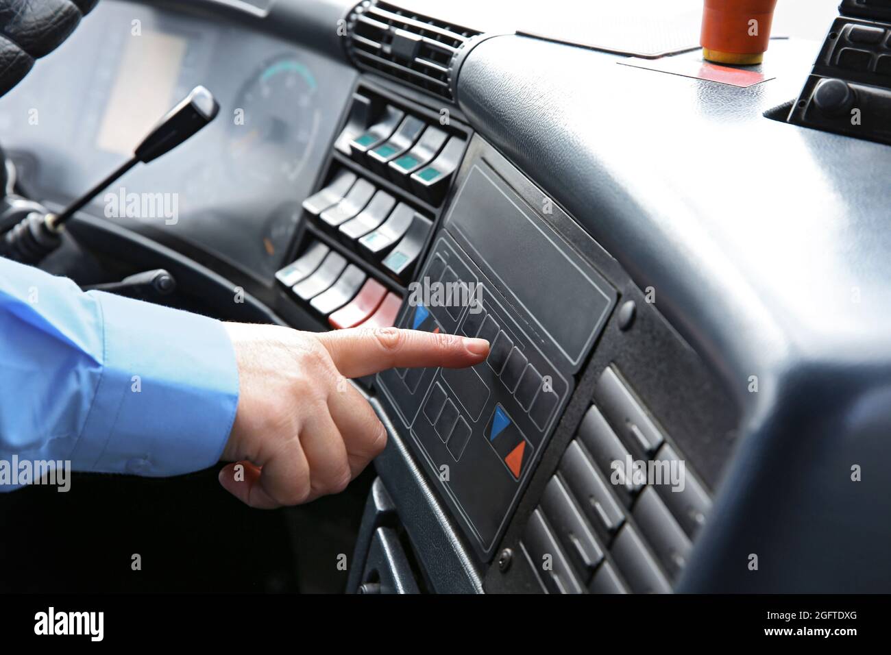 Bus driver pushing button on panel Stock Photo - Alamy