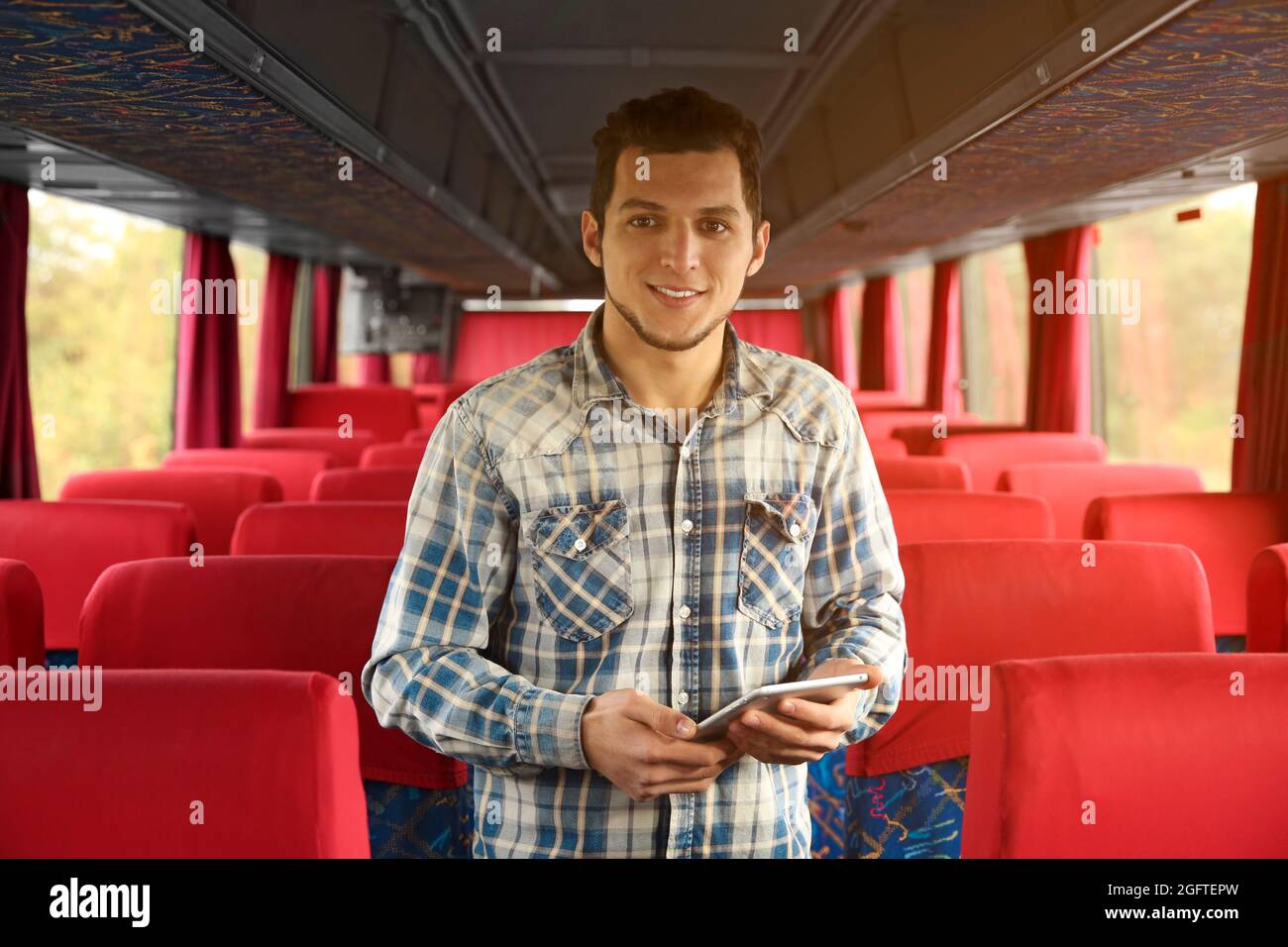Conductor inside bus with clipboard Stock Photo - Alamy