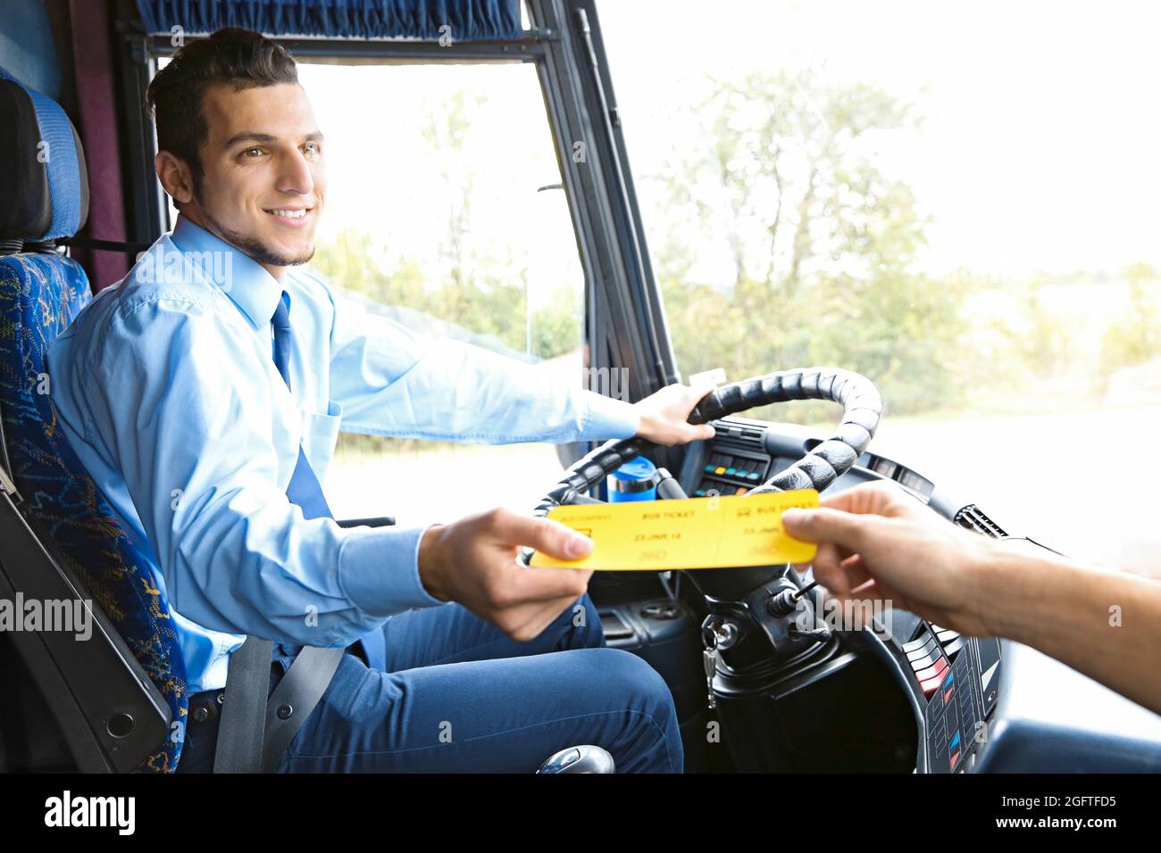 Bus driver taking ticket from passenger Stock Photo - Alamy