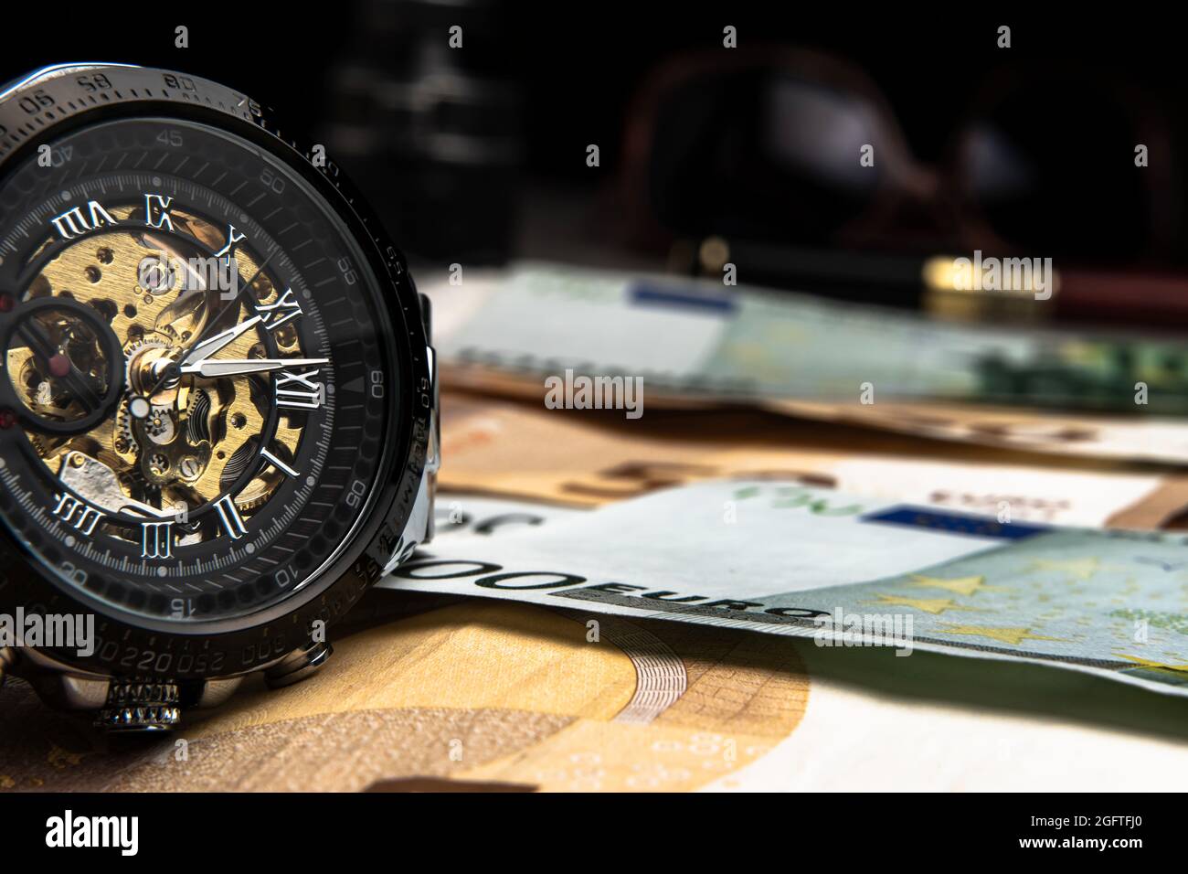 Time is money.A beautiful mechanical watch in close-up lies on the euro ...