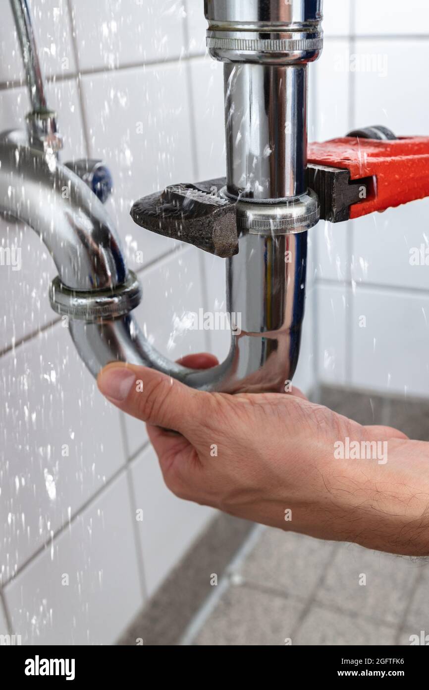 Plumber Repairing Pipe Water Leak. Fixing Plumbing Stock Photo - Alamy