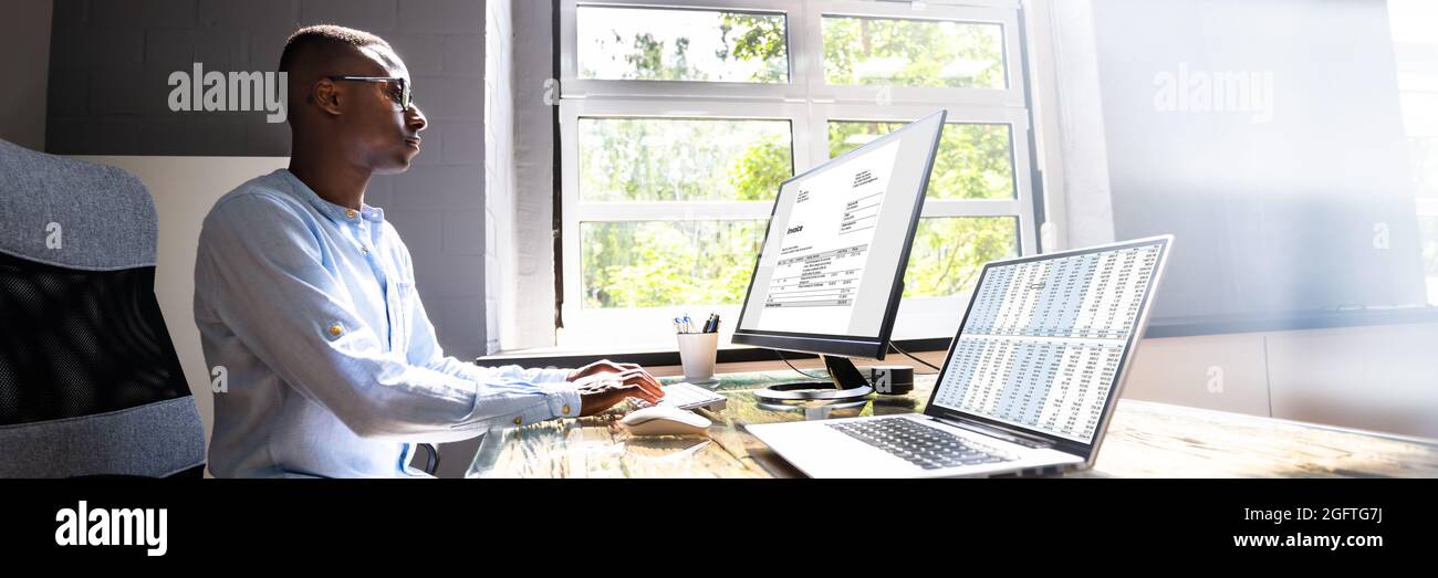 African American Tax Accountant Checking Invoice On Office Computer ...