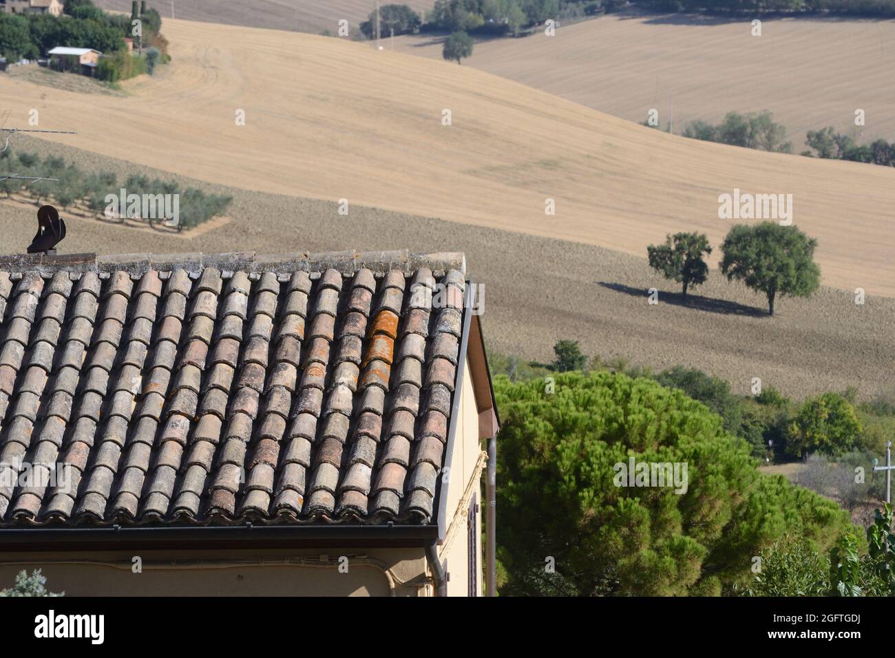 typical Italian tiled roof. Rolling cultivated field on the background ...