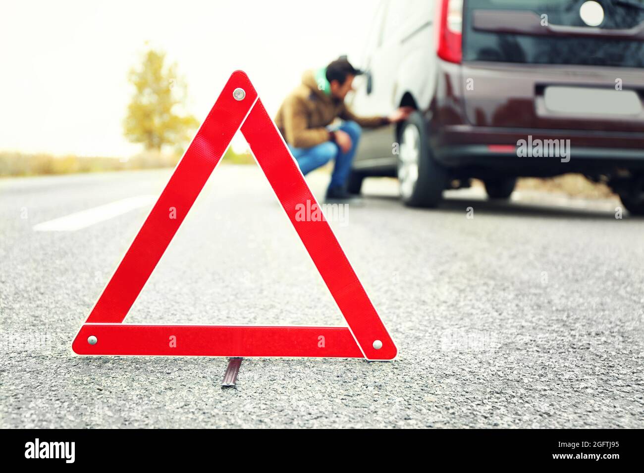 Traffic warning sign on road with car and driver on background Stock ...