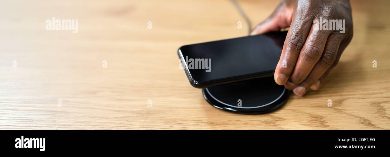 Man Charging Smartphone Using Wireless Charging Pad At Home Stock Photo ...
