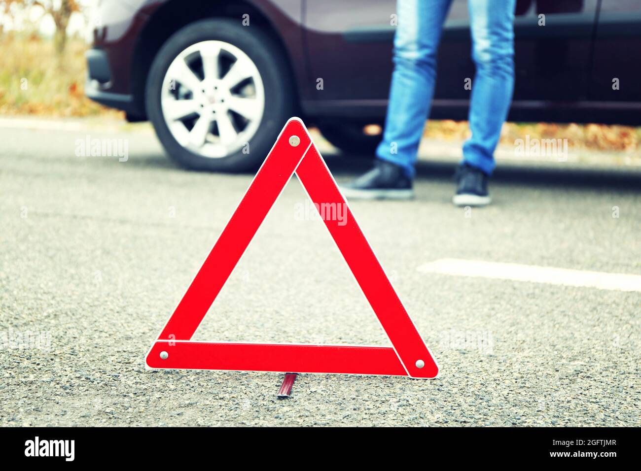 Traffic warning sign on road with car and driver on background Stock ...