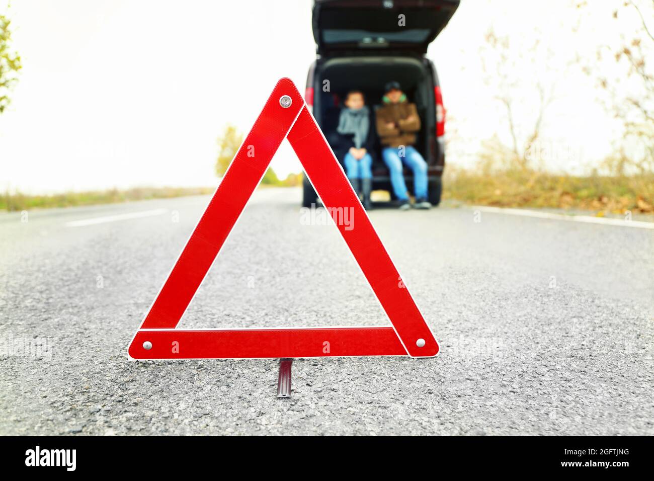 Traffic warning sign on road with car and couple on background Stock ...
