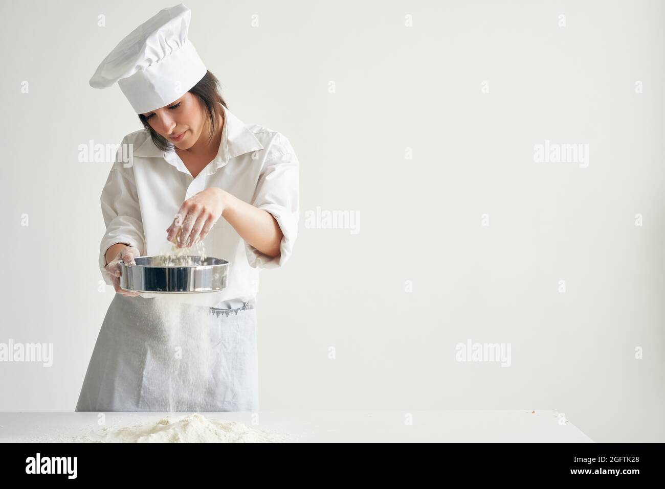 woman chef sifting flour on the table bakery cooking pastry Stock Photo ...