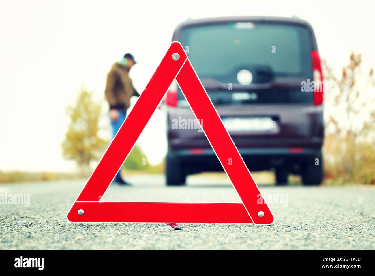Traffic warning sign on road with car and driver on background Stock ...