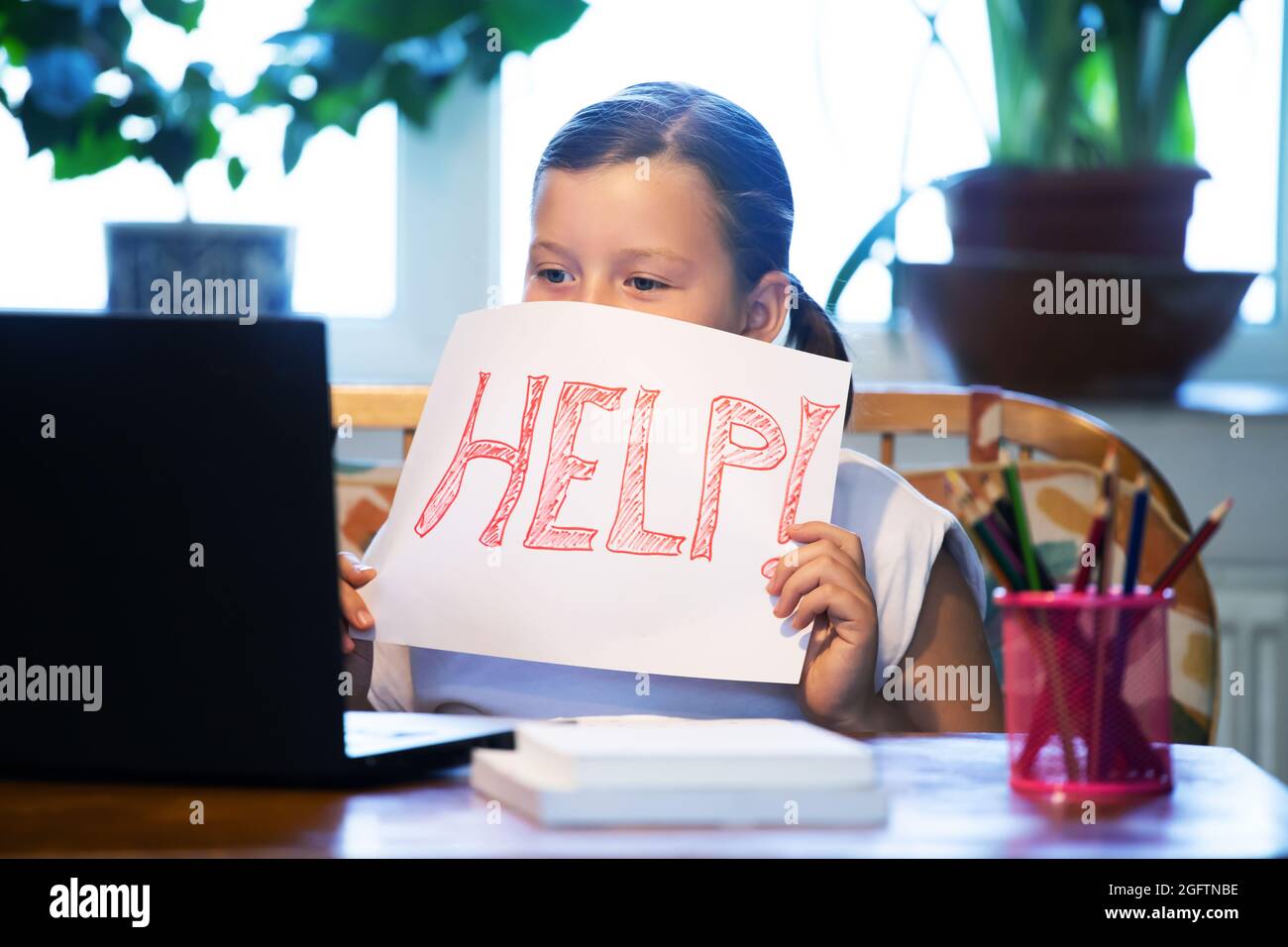 Distance learning concept. School girl holding help text during online ...