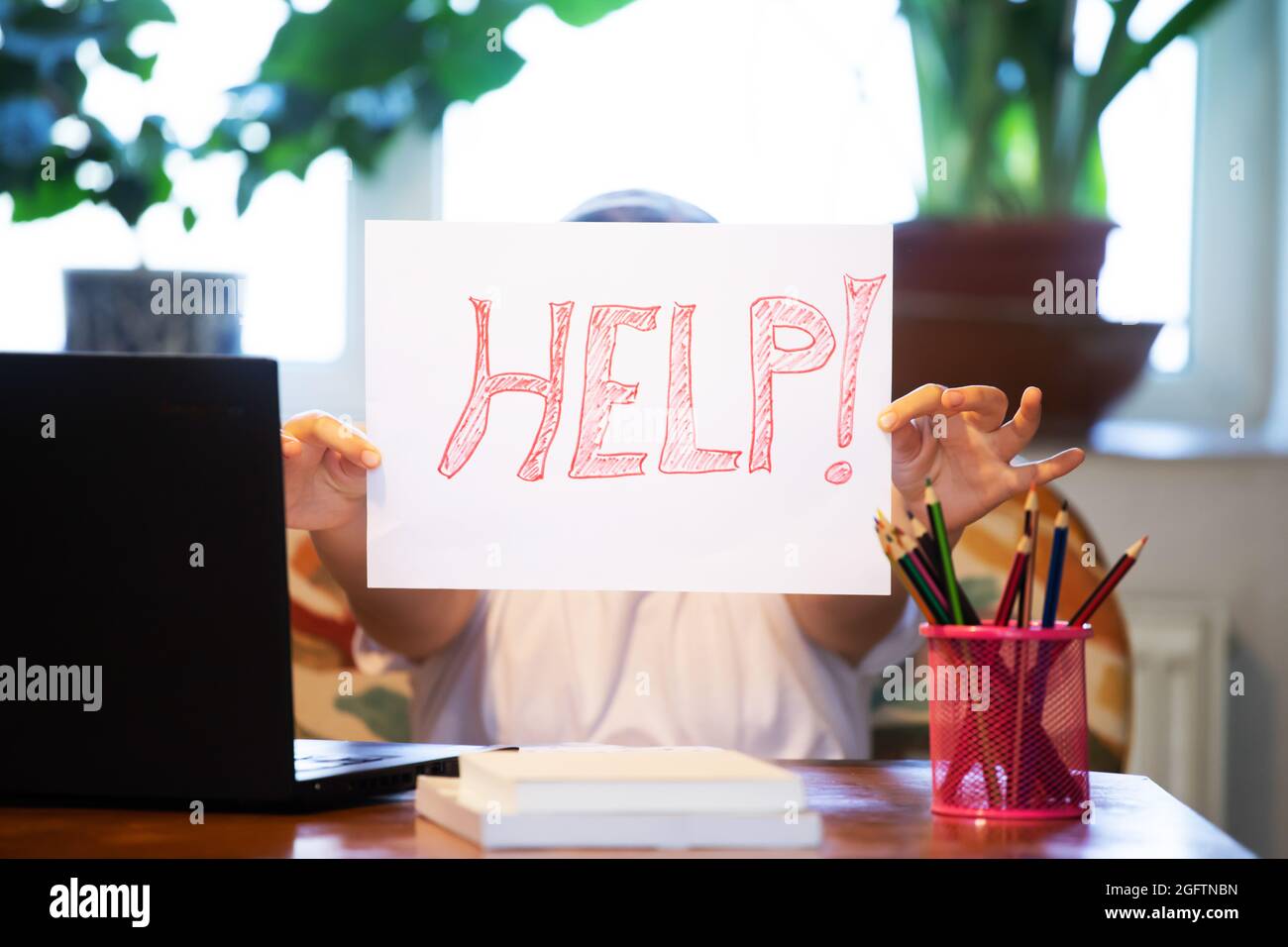 Distance learning concept. School girl holding help text during online ...