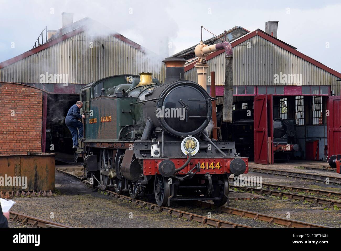 Loco Driver climbs into the cab of Great Western Prairie tank loco 4144 ...