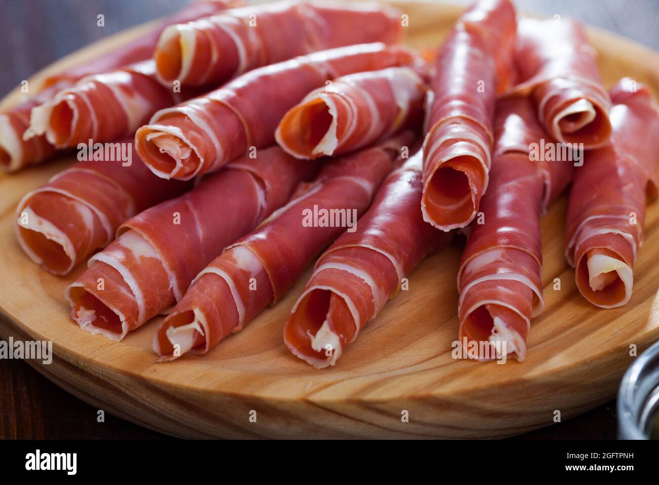 Spanish tasty meal rolls of prosciutto di parma at wooden desk Stock ...