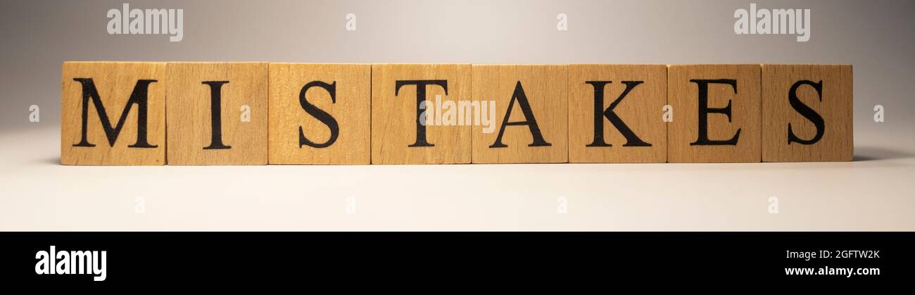 The word mistake written with a pencil on white paper. An eraser from a ...