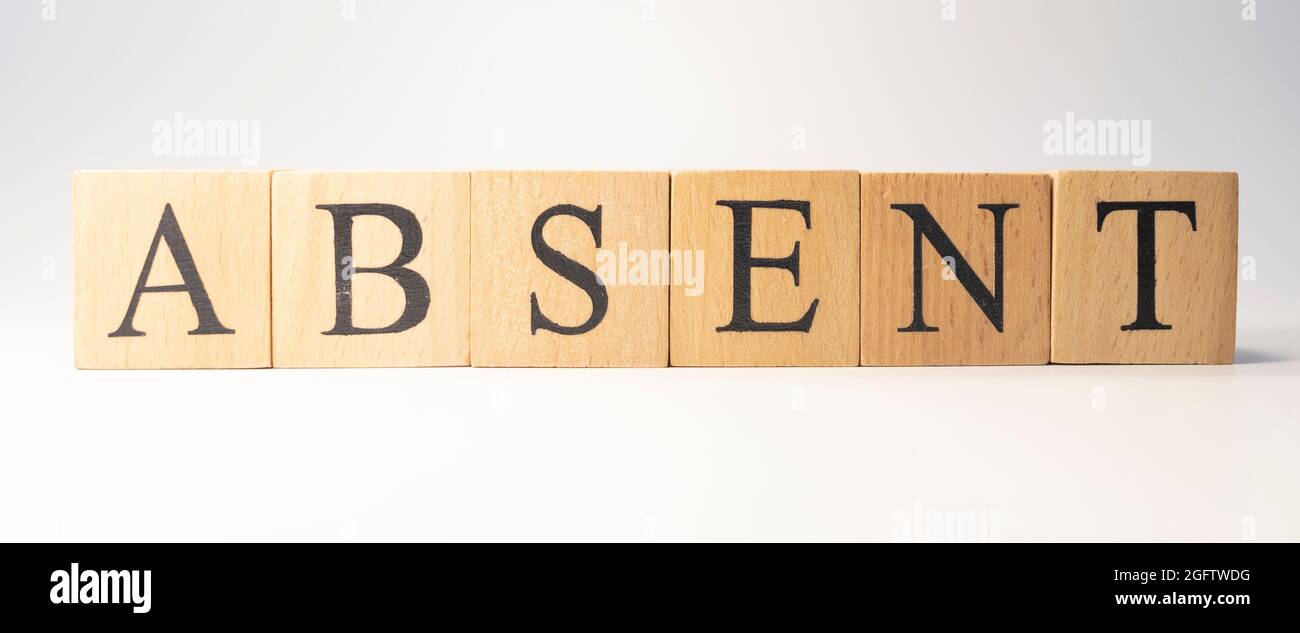 The word ABSENT was created from wooden cubes. work and life. Close-up ...