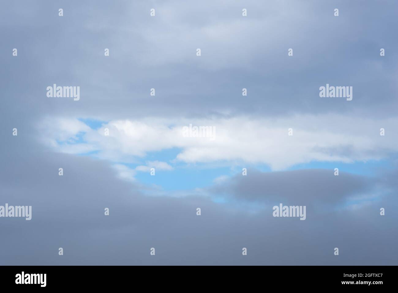 Blue-gray clouds in the sky before the rain. Light blue sky behind dark ...