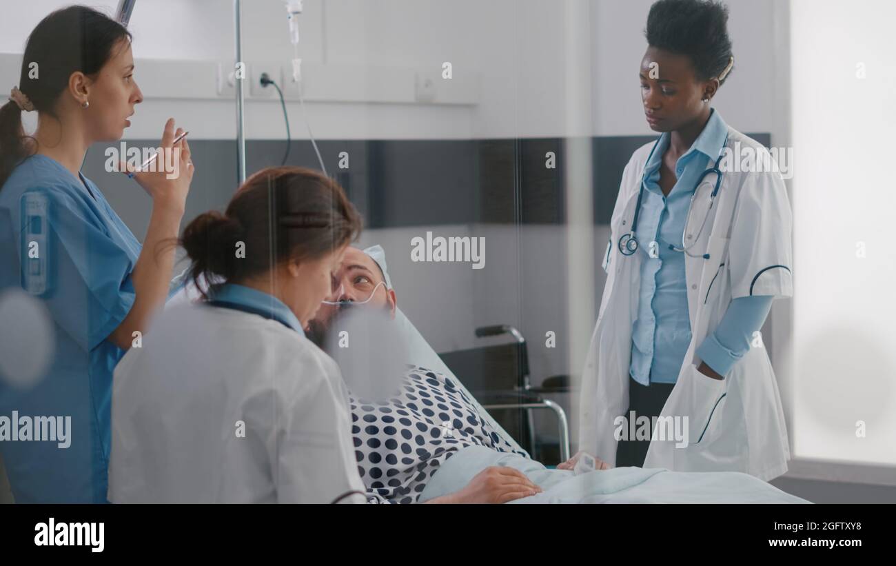 Doctors team monitoring man explaining disease symptom monitoring ... Doctors team monitoring man explaining disease symptom monitoring ...