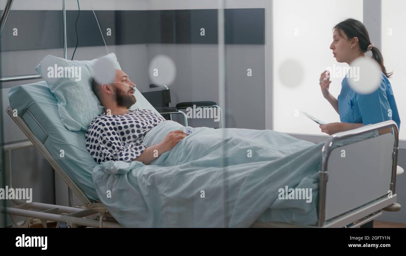 Medical nurse explaining bones radiography to hospitalized sick man ...