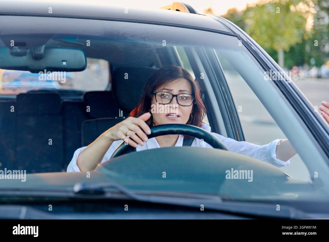 Middle-aged woman driver with glasses, female driving a car Stock Photo ...