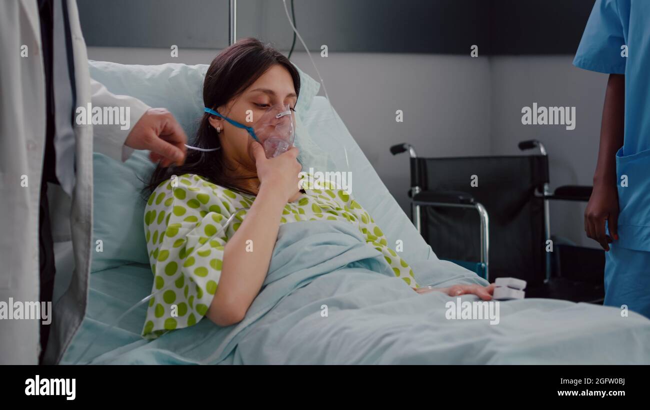 Patient resting in bed having respiratory illness while doctors ...