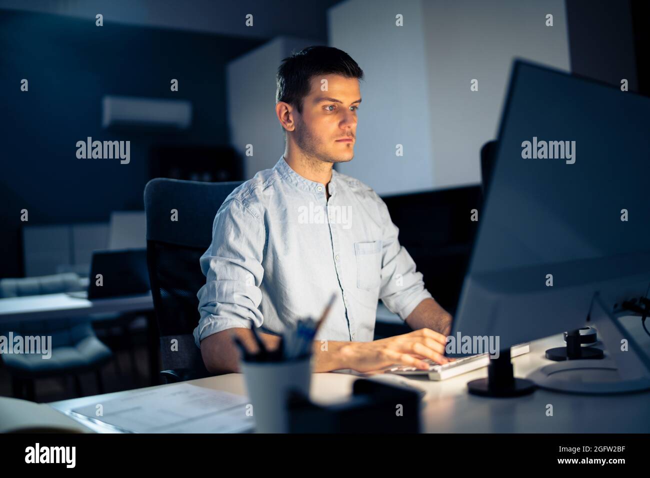 Young man working in office late night hi-res stock photography and ...
