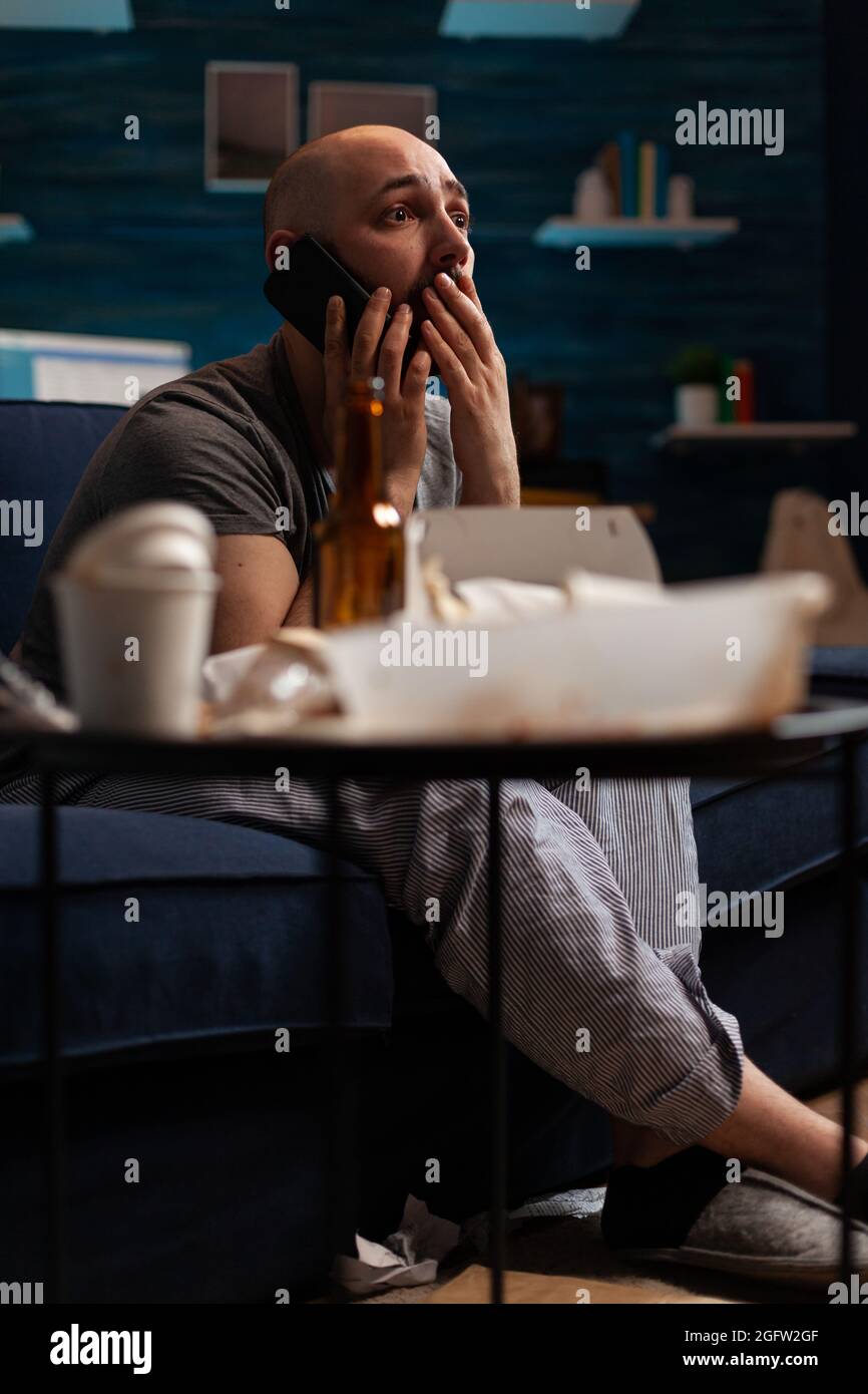 Unhappy depressed shocked man with chronic disease reading tragedy news ...