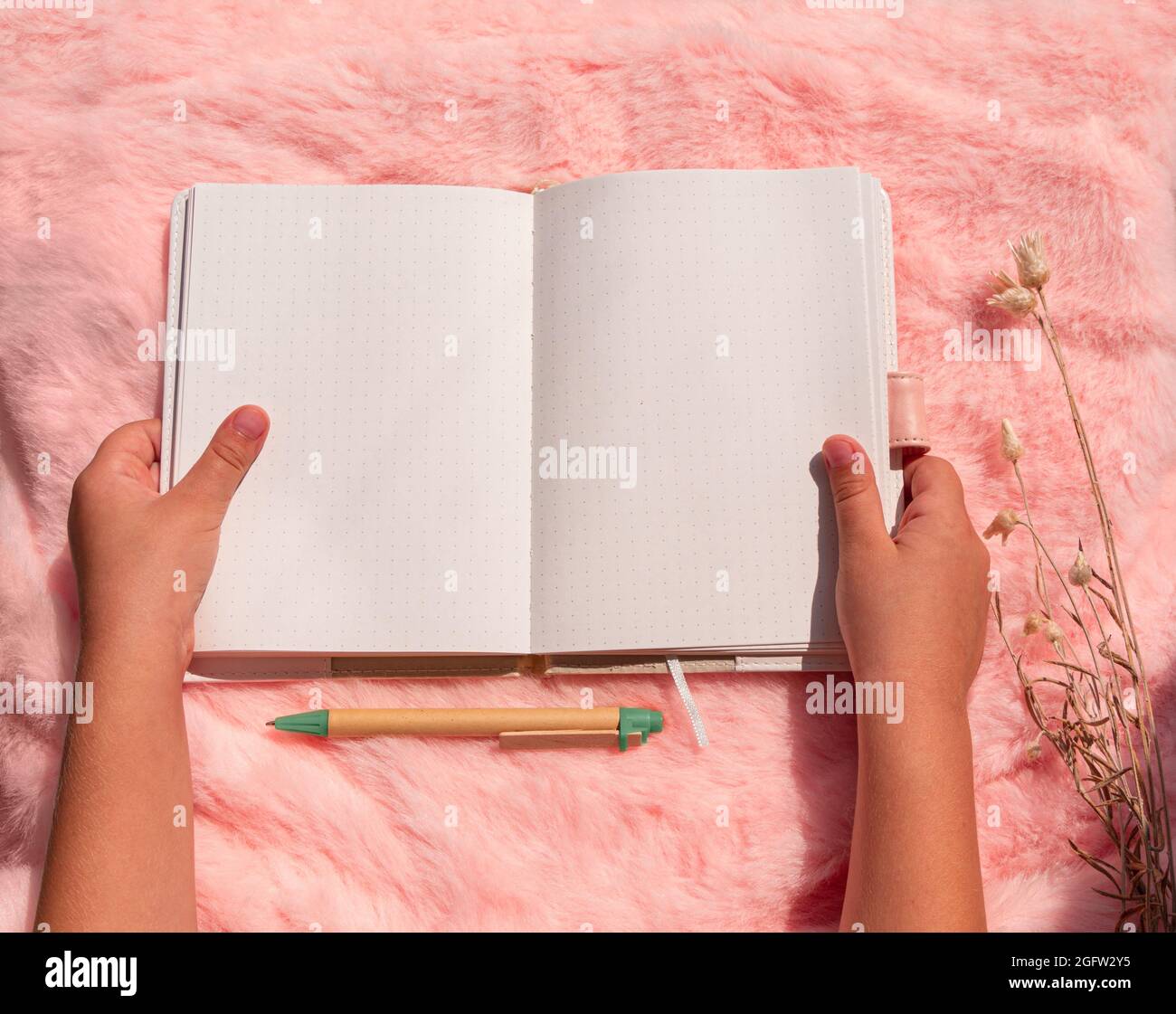 Blank notebook mockup in hands on pink faux fur. Coral fluffy feminine ...