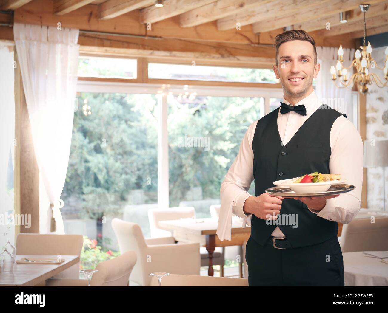 Handsome young waiter at restaurant Stock Photo - Alamy