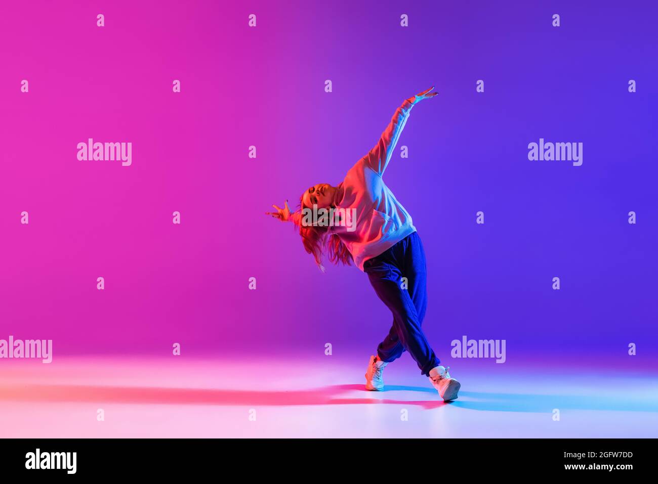Young beautiful girl, female hip-hop dancer isolated on gradient pink ...