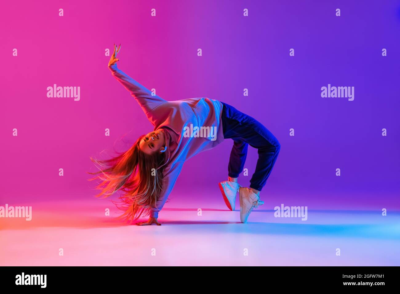 Beautiful active young girl dancing and showing hip-hop tricks isolated ...