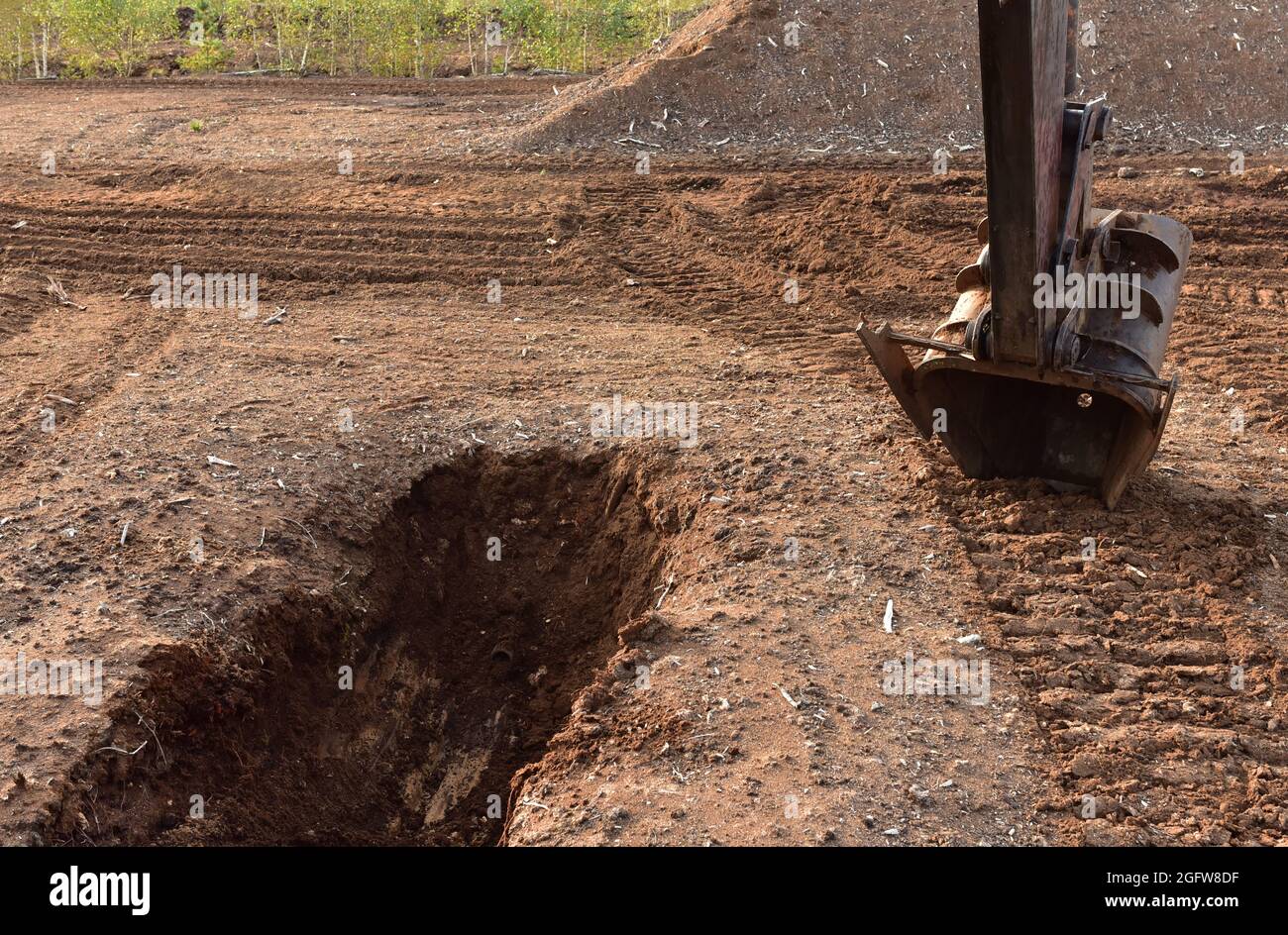 Excavator digging drainage ditch in peat extraction site. Drainage of ...