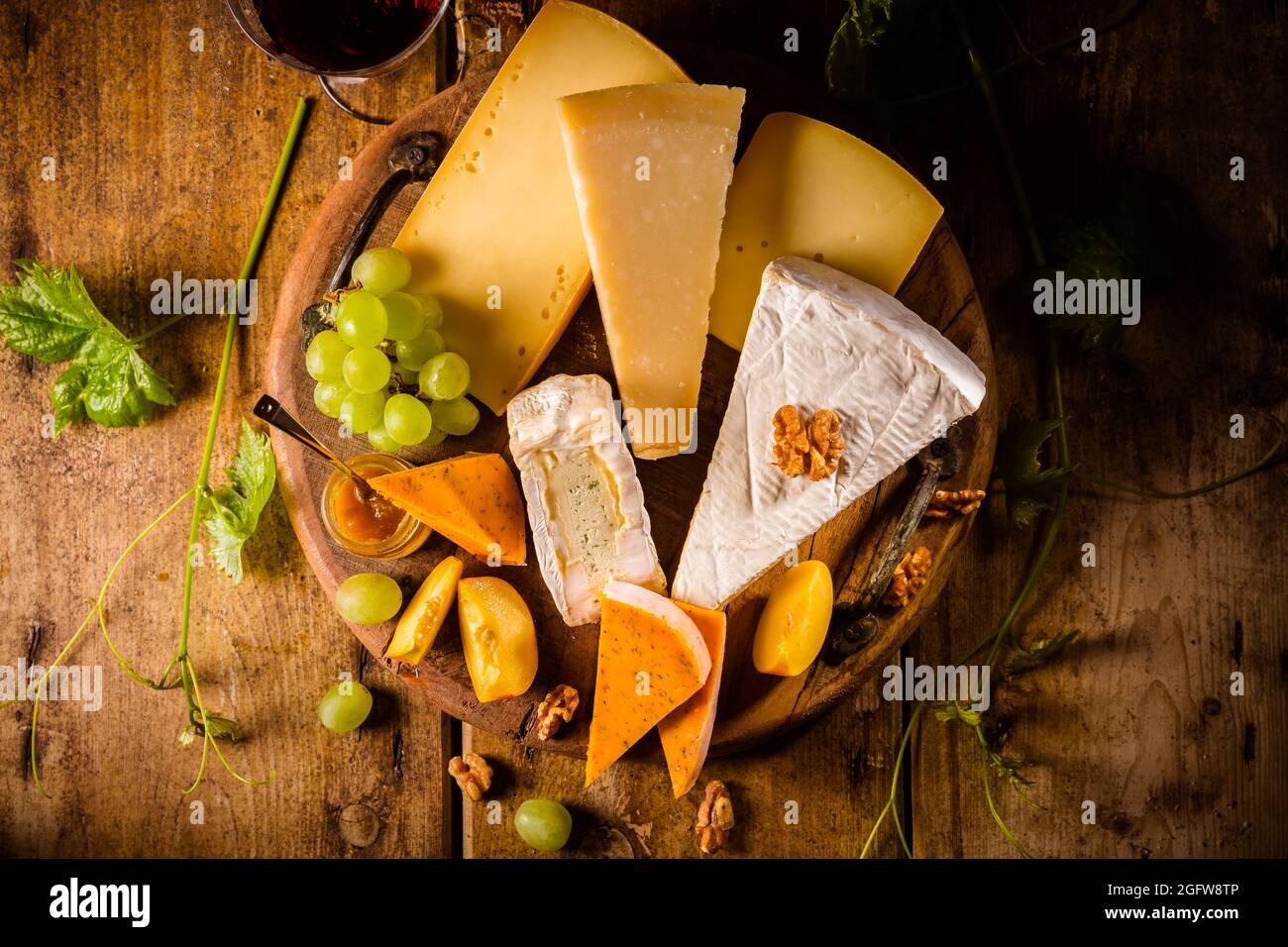Cheese platter, assortment of different cheeses with glass of red wine ...