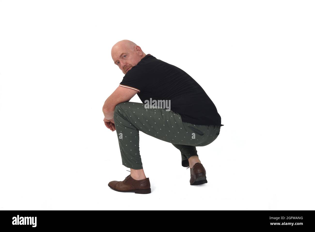 side view of a man sitting squatting on white background Stock Photo ...