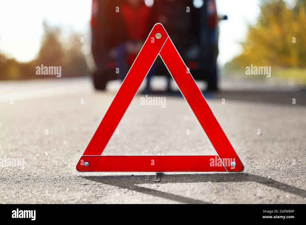 Close up view of red warning triangle on asphalt road. Emergency stop ...
