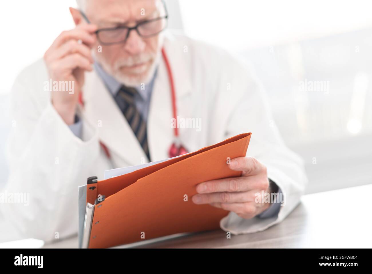 Doctor reading a medical report in office Stock Photo - Alamy
