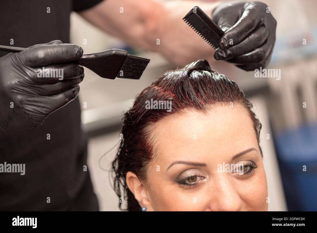 Hairdresser coloring client hair Stock Photo - Alamy