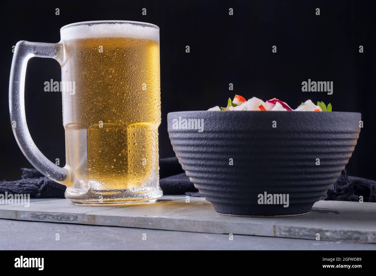a mug of cold beer and a bowl of ceviche Stock Photo - Alamy