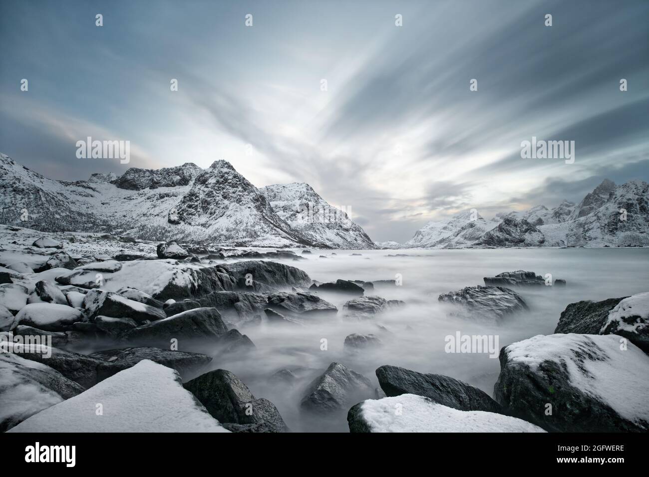 Coastal landscape in winter with water movement between large stones ...