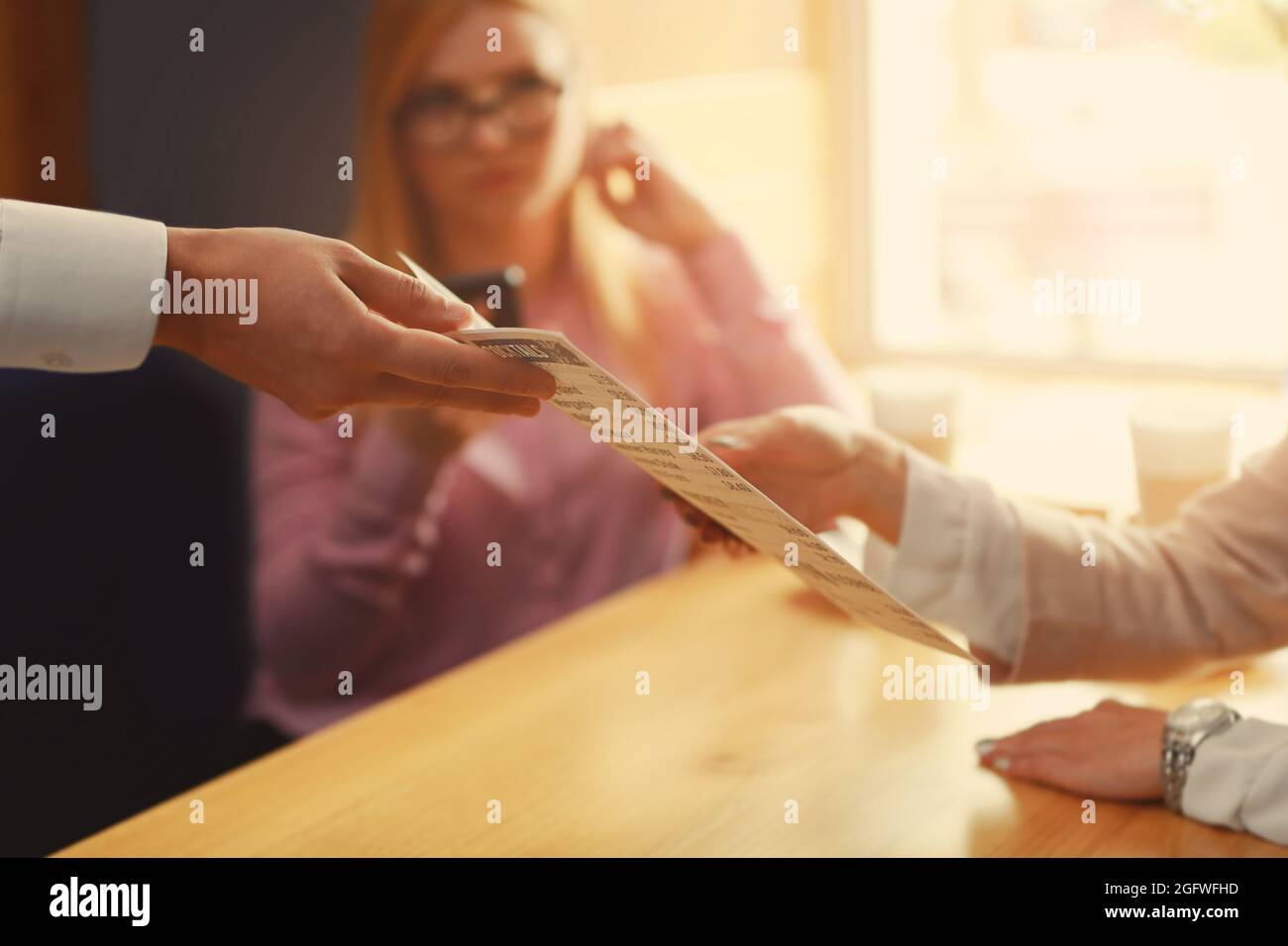 Hand of waiter showing menu to young woman, close up view Stock Photo ...