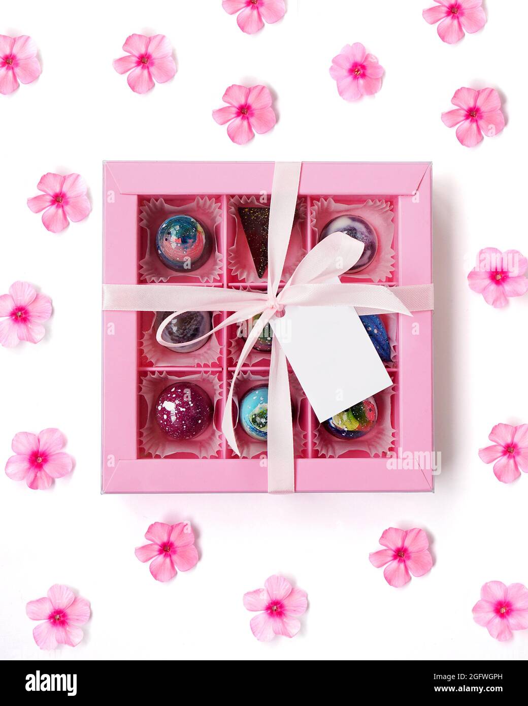 Chocolate candy. Pink gift box with handmade chocolates on white with ...