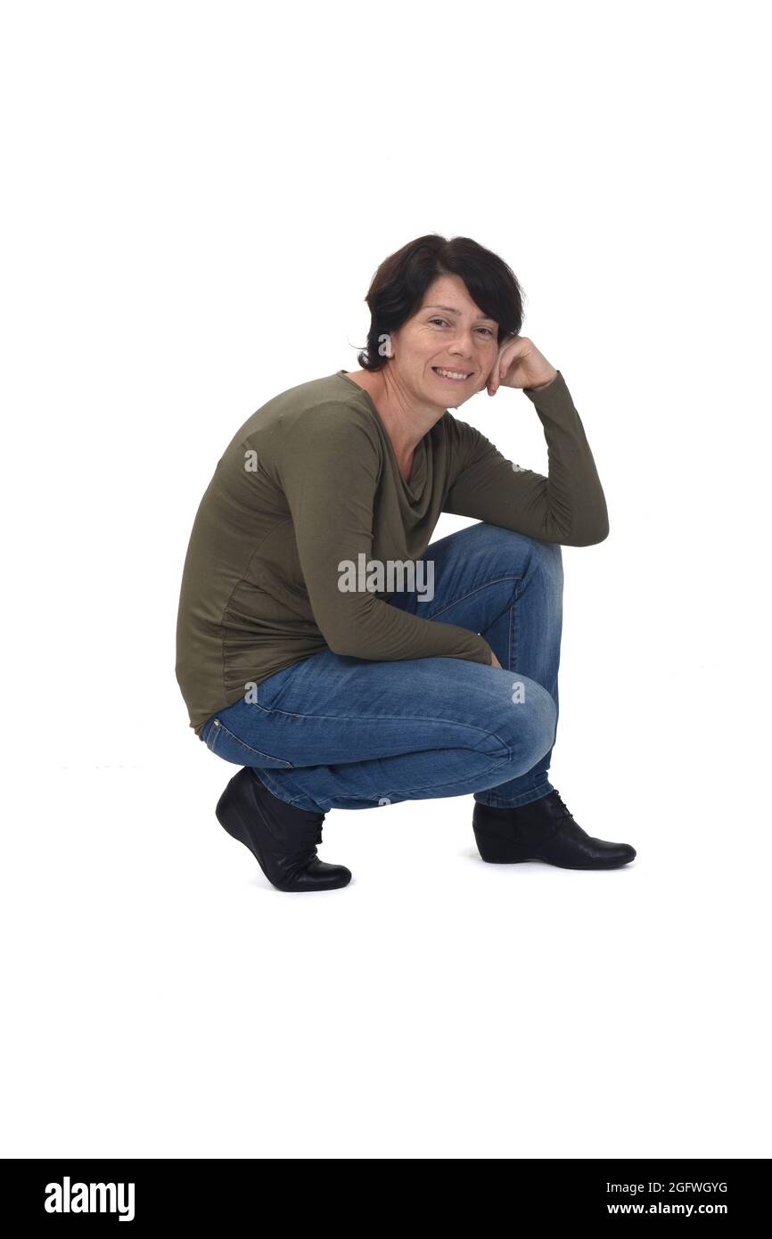 side view of a woman crouching and hand on face on white background ...