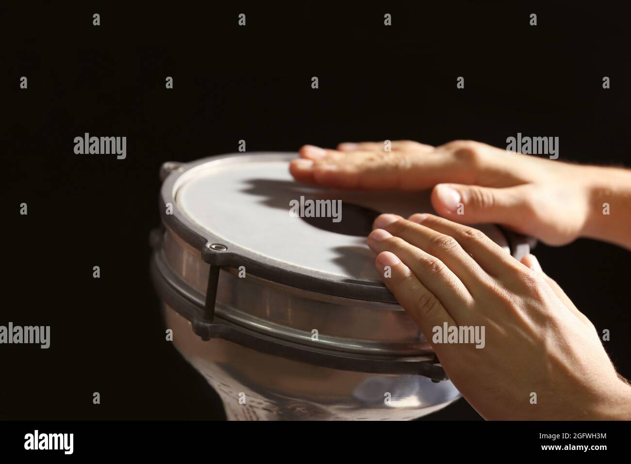 Hands of man playing African drum on dark background Stock Photo - Alamy
